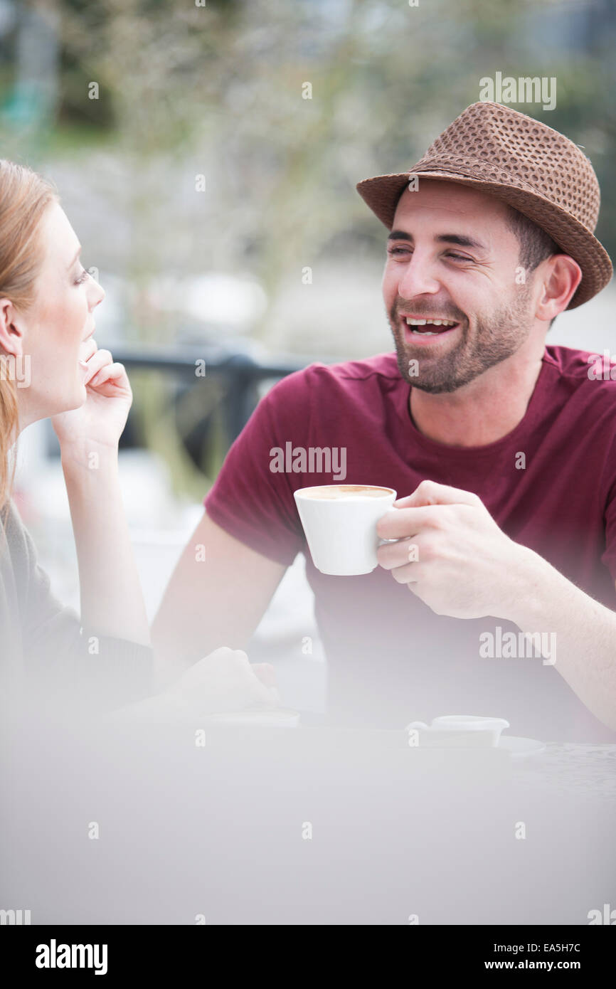 Portrait of laughing man having a coffee break with his girlfriend ...