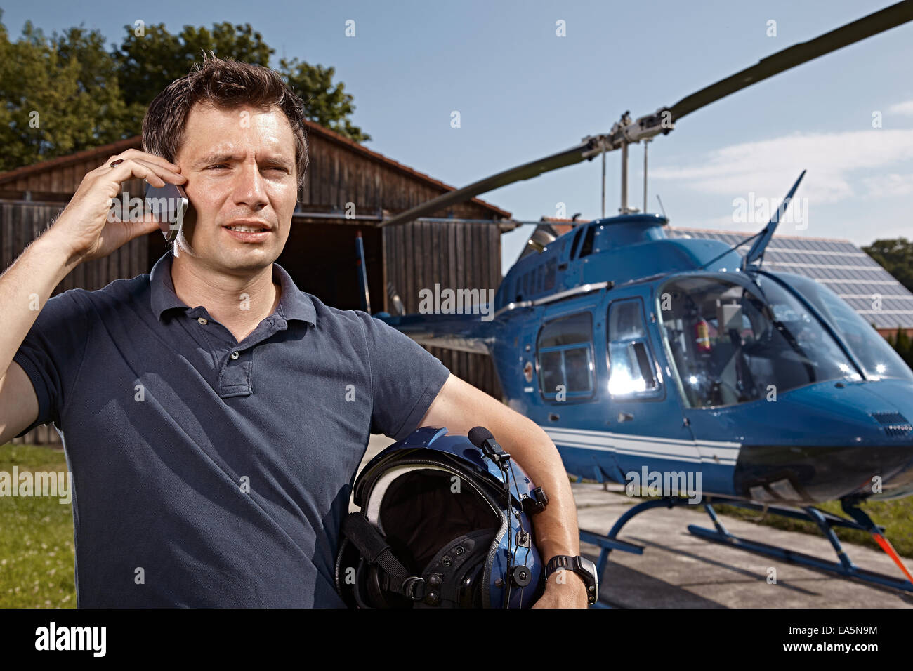Germany, Bavaria, Landshut, Helicopter pilot using mobile phone Stock ...