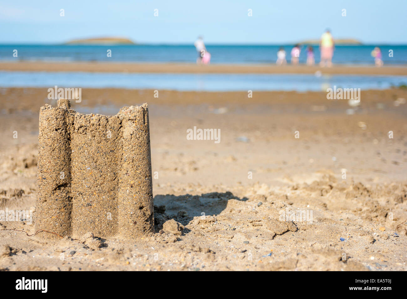 Sad castle on the beach with family playing at background Stock Photo ...