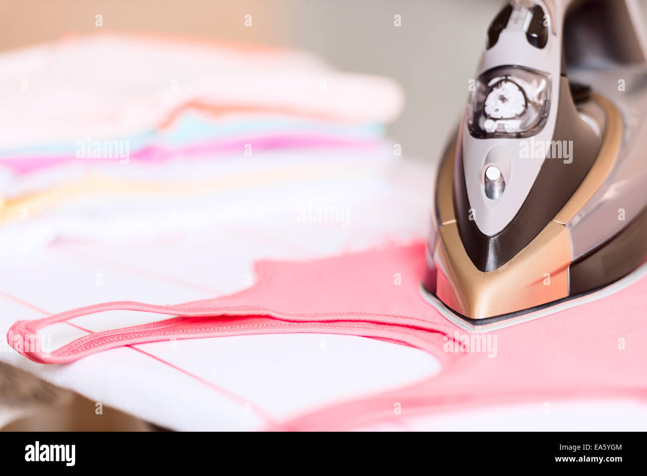 Iron and cloth on ironing table macro Stock Photo - Alamy