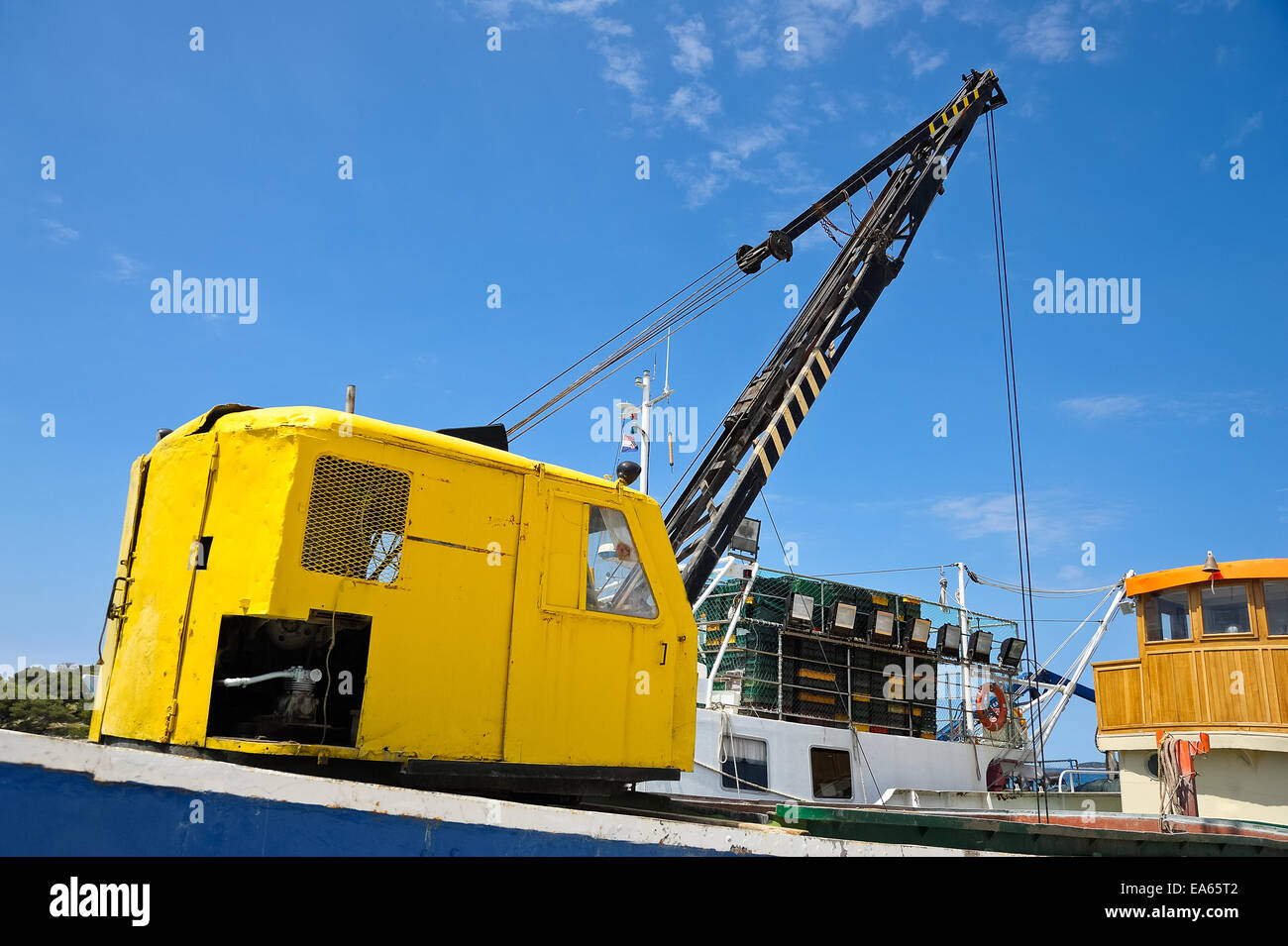 Yellow crane on fishing boat Stock Photo - Alamy