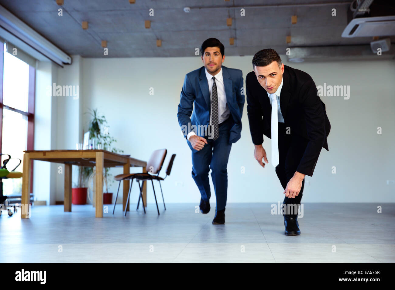 Two businessman running together in office. Business concept Stock ...