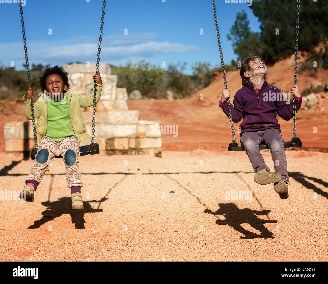 Two girls sitting on a swing Stock Photo - Alamy