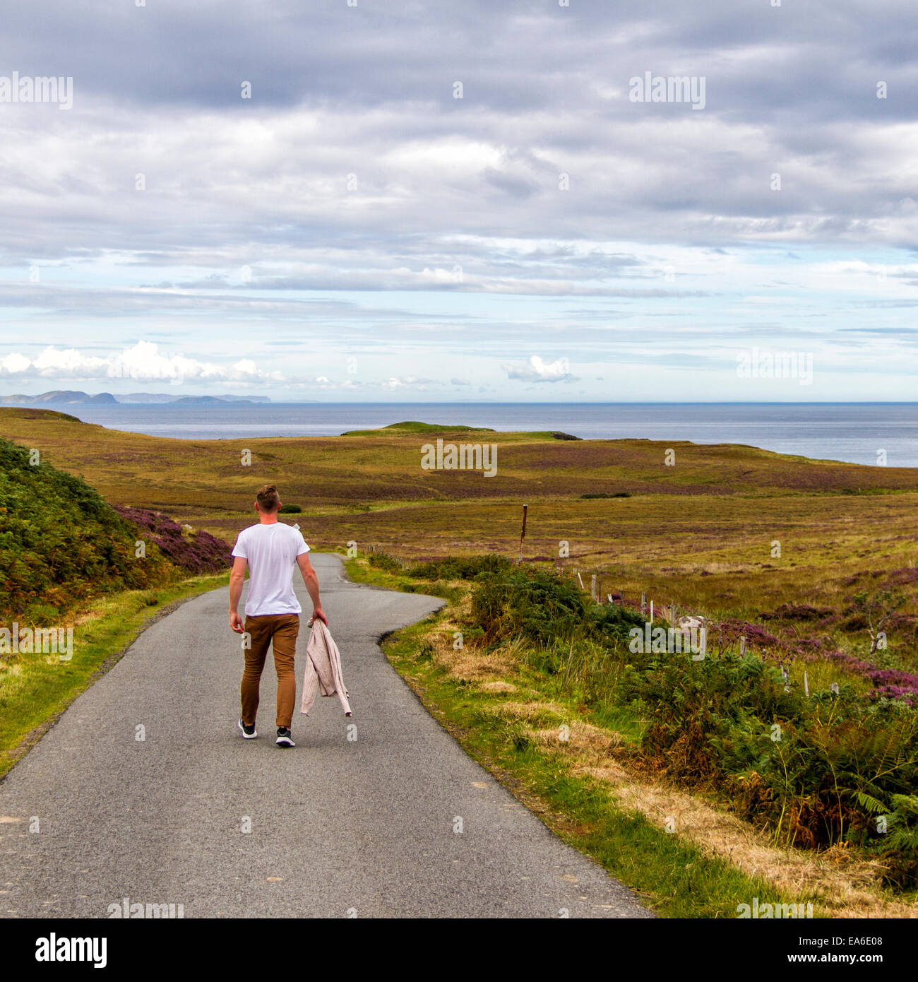 UK, Scotland, Man walking towards Skye Stock Photo - Alamy