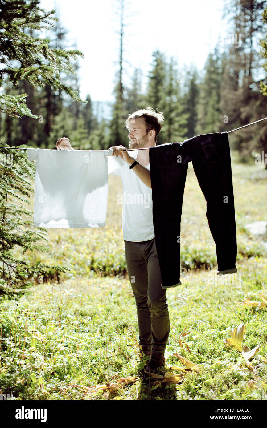 Man hanging laundry in meadow Stock Photo - Alamy