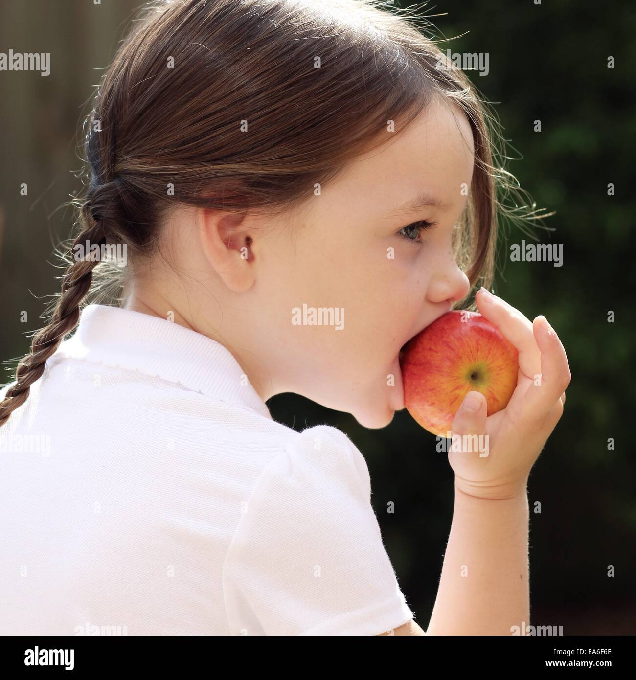 Portrait of a girl eating apple Stock Photo - Alamy