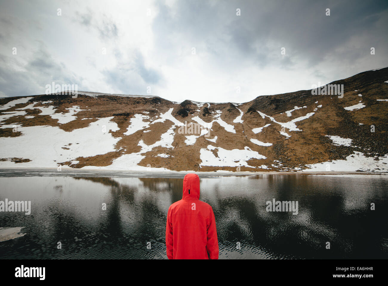 Back view of young man looking at mountain lake Stock Photo - Alamy