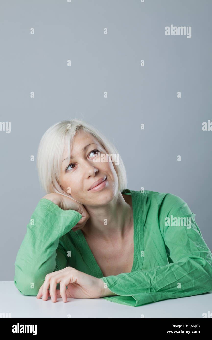 Woman thinking at table hi-res stock photography and images - Alamy