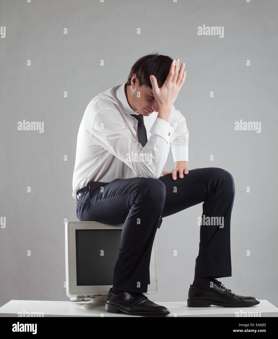 young man sitting on the monitor Stock Photo - Alamy