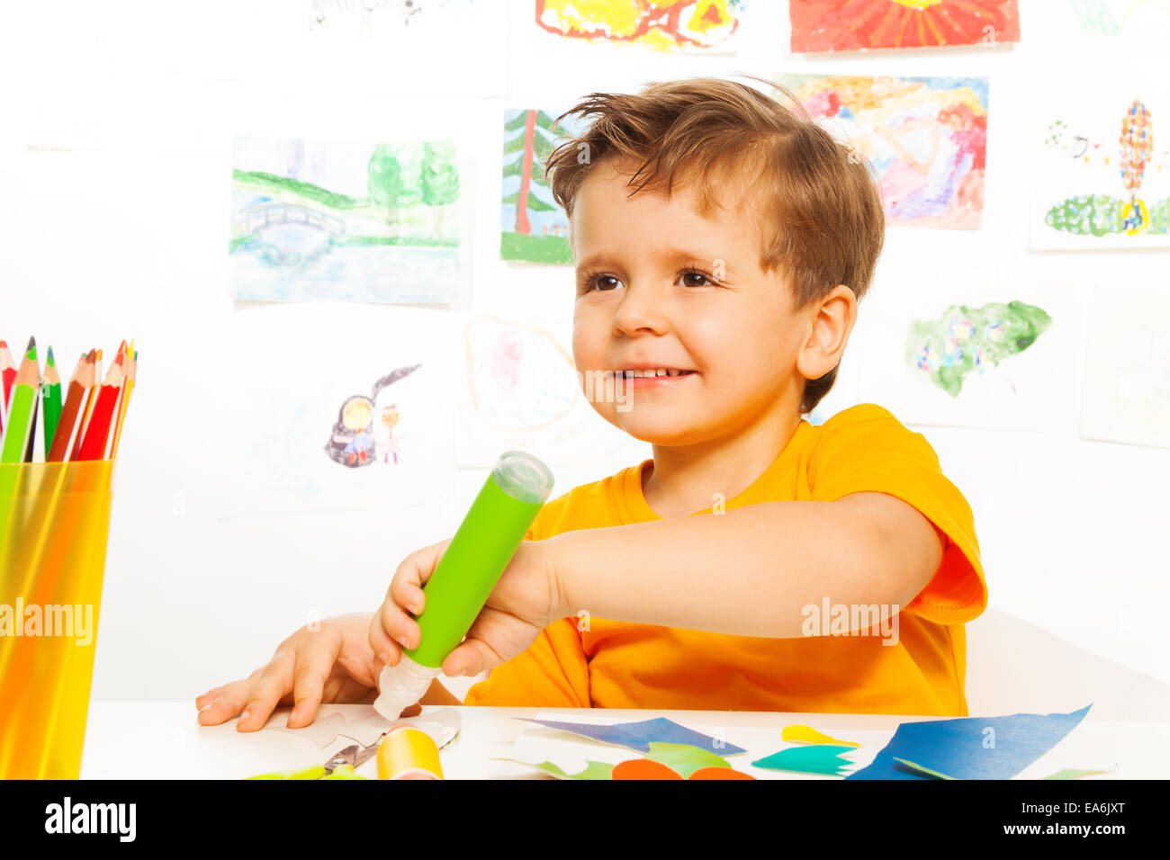 Happy small boy crafting while gluing paper Stock Photo - Alamy
