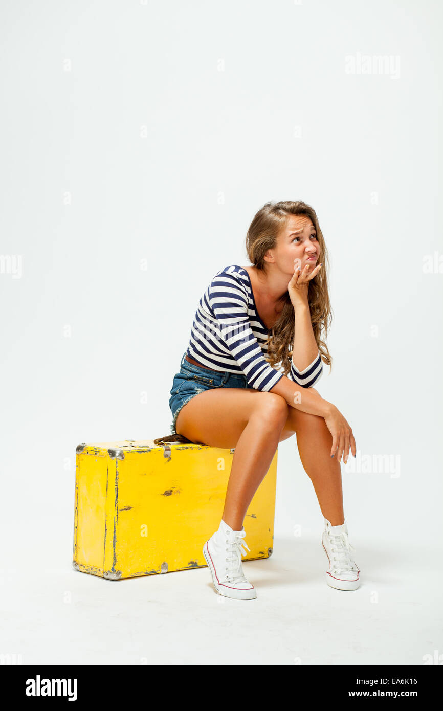 girl sitting on a suitcase Stock Photo - Alamy