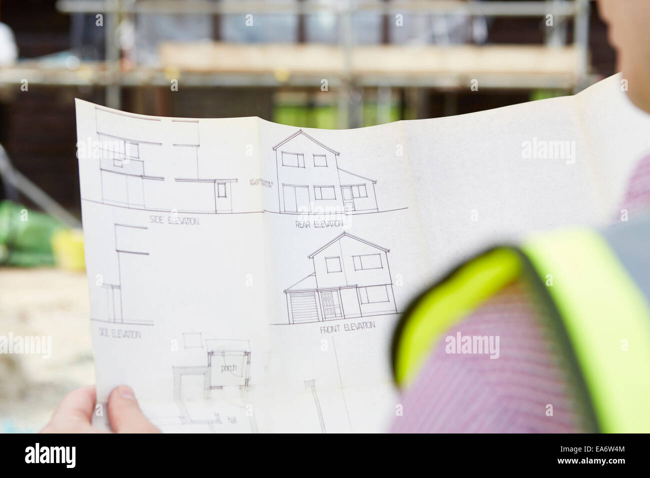 Architect On Building Site Looking At Plans For House Stock Photo - Alamy