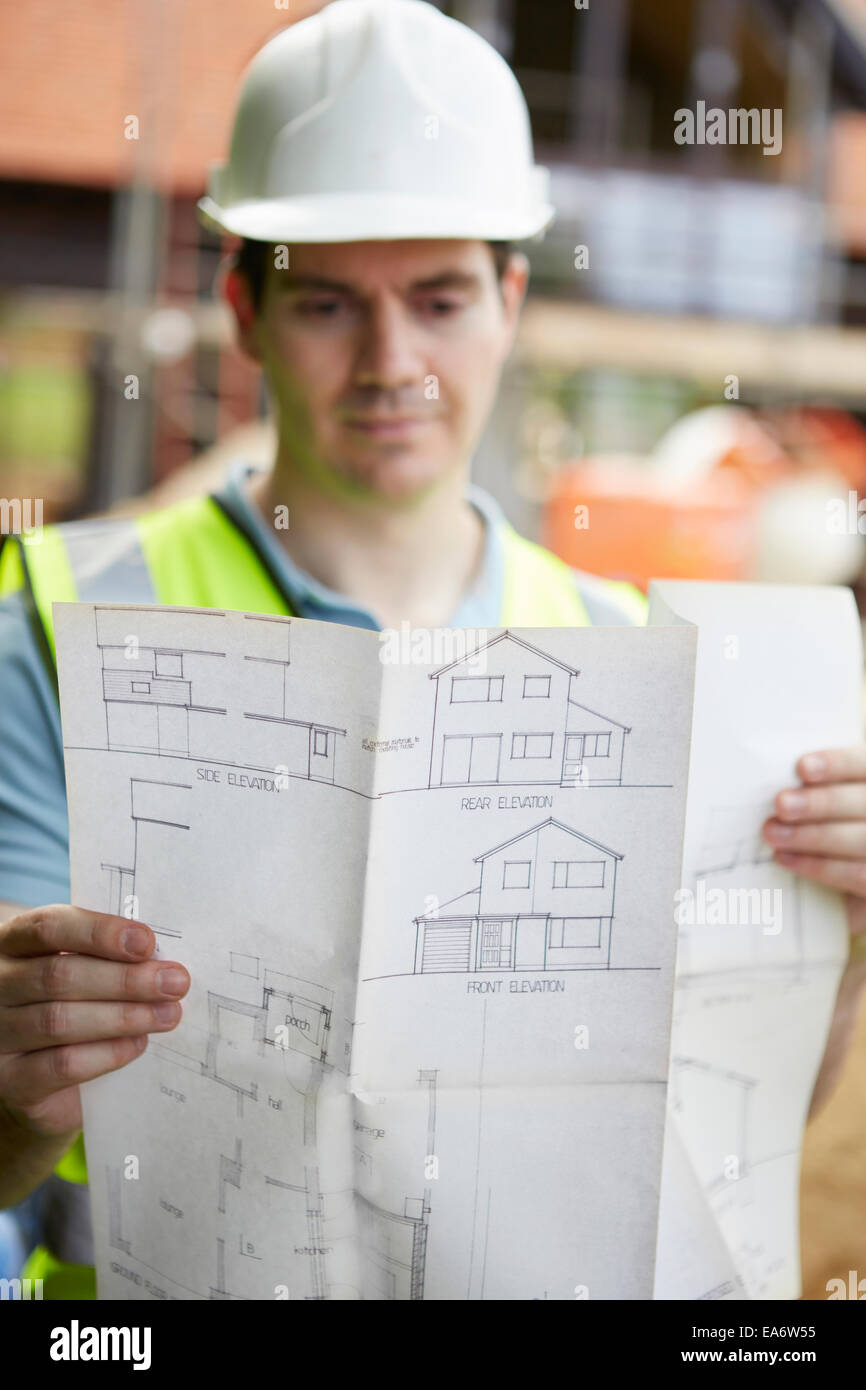 Construction Worker On Building Site Looking At House Plans Stock Photo ...