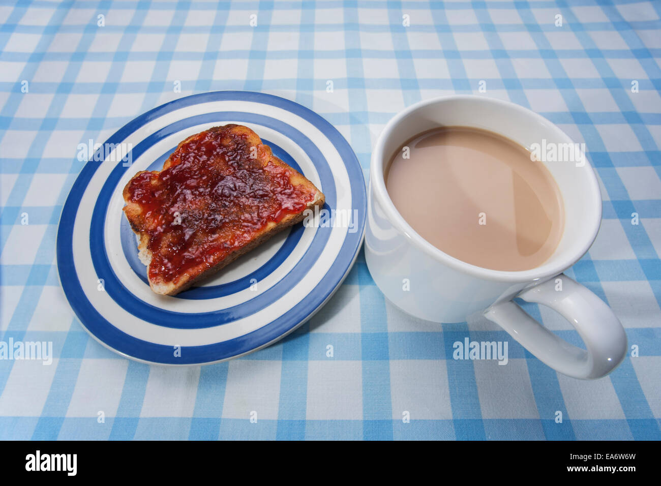 Jam on toast and a mug of tea on a check table cloth Stock Photo - Alamy
