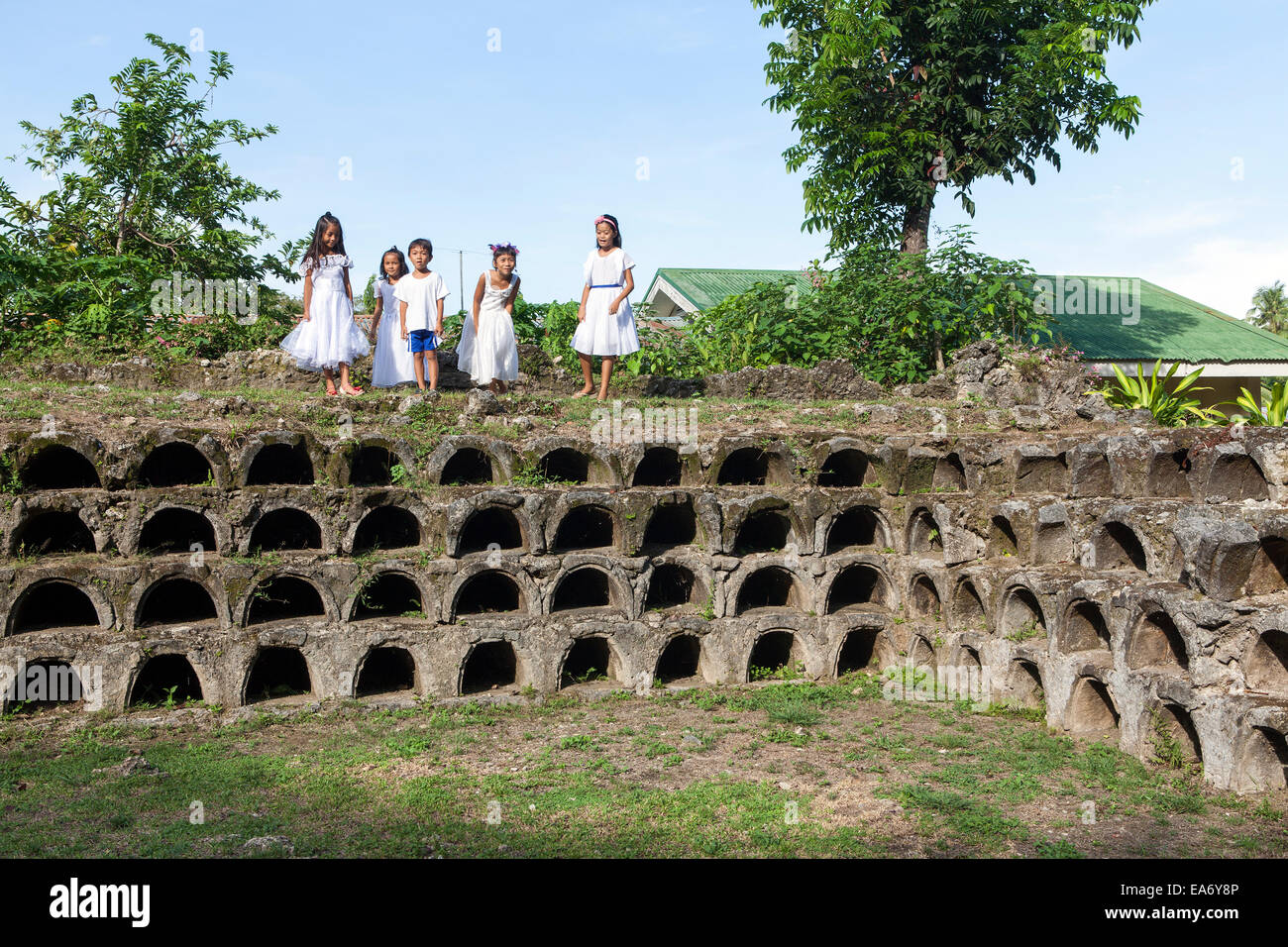 Five Filipino children play on the walls of the old Spanish chapel ...