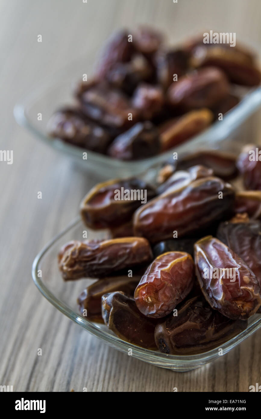 Dates, traditional Ramadan fruit in glass dishes on wooden table Stock ...