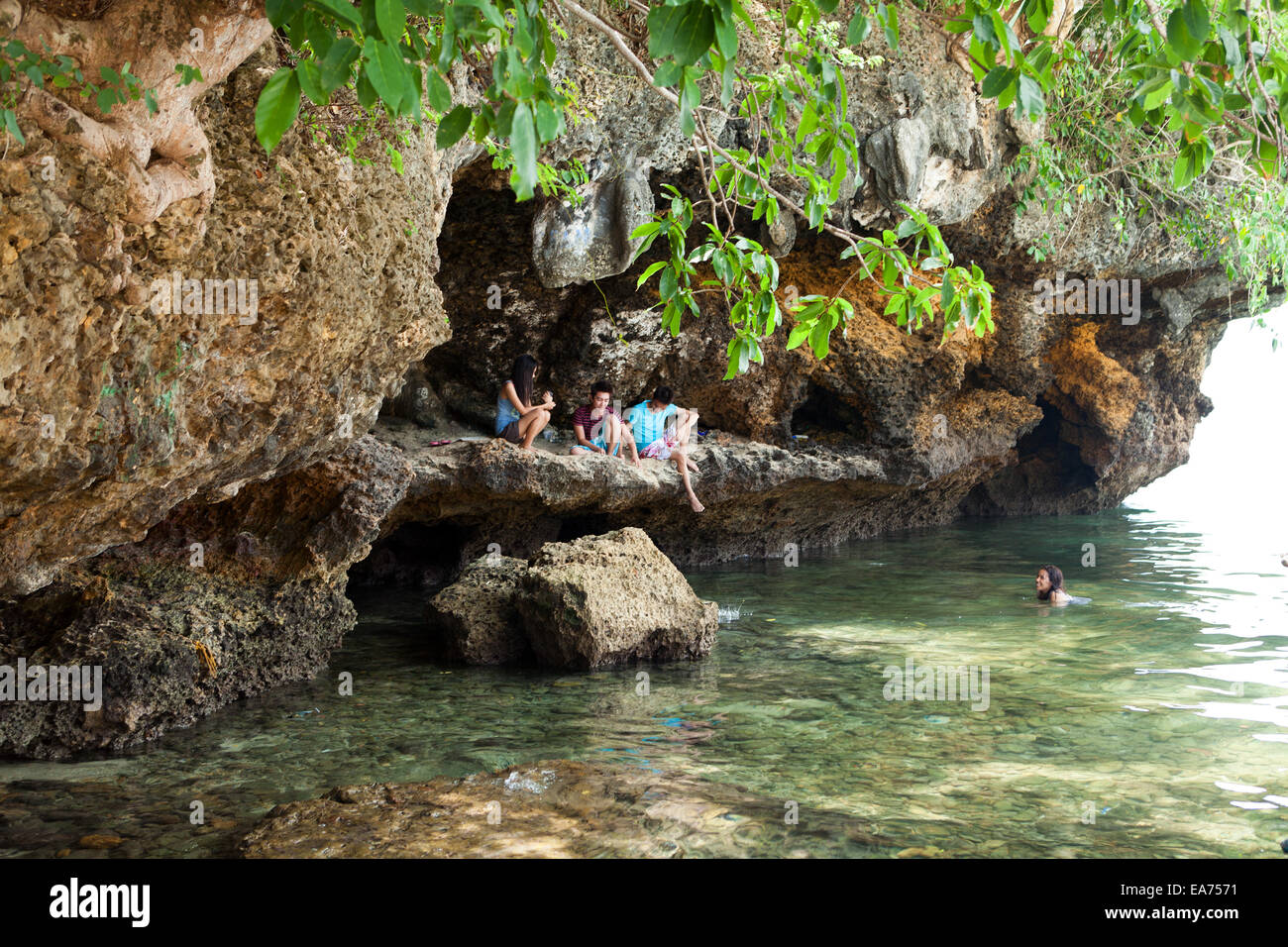 Filipino teenagers swim and relax in karst cave at Alubihod Beach ...