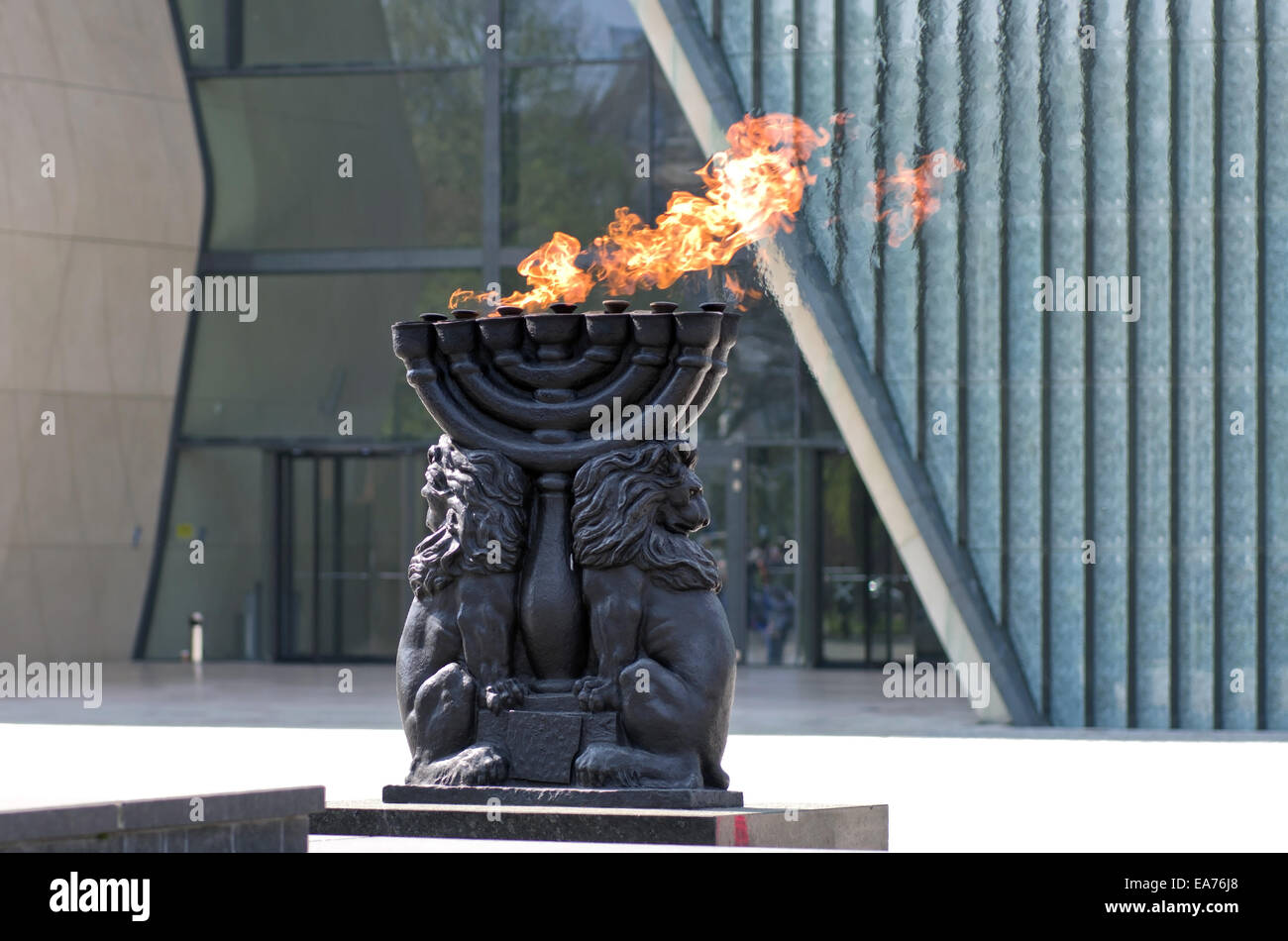 Menorah with burning flame and the facade of the Museum of the History ...