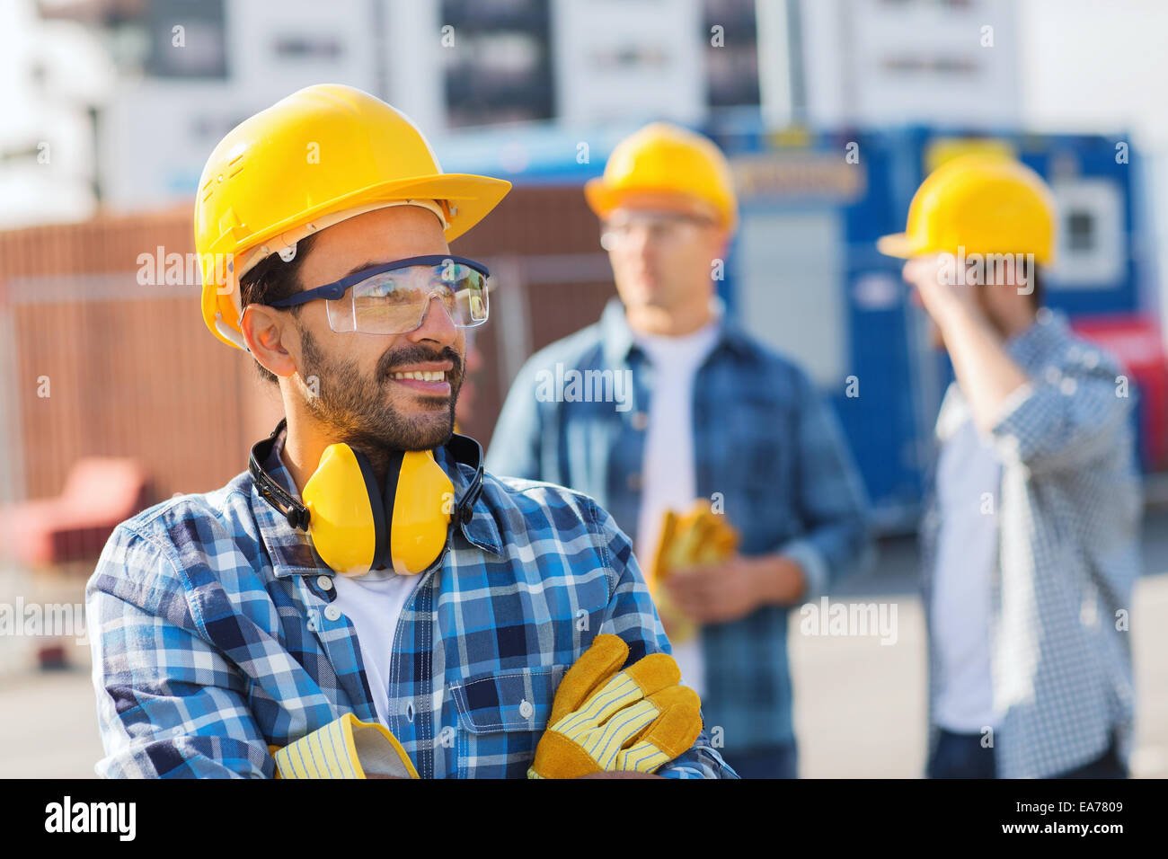 group of smiling builders in hardhats outdoors Stock Photo - Alamy