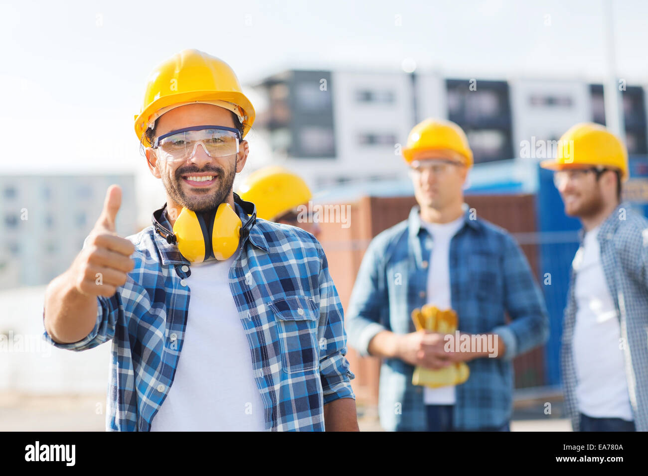 group of smiling builders in hardhats outdoors Stock Photo - Alamy