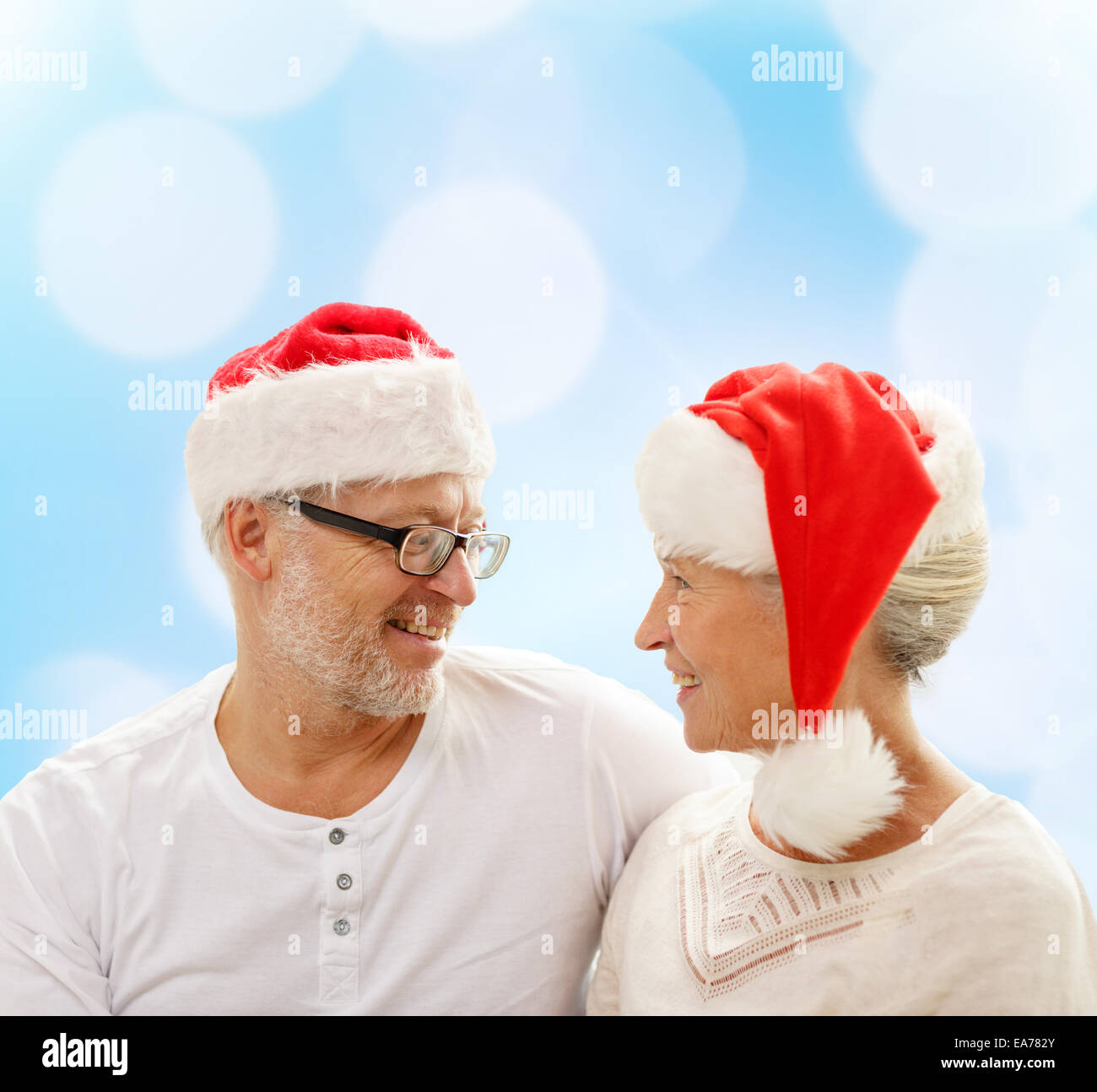 happy senior couple in santa helper hats Stock Photo - Alamy