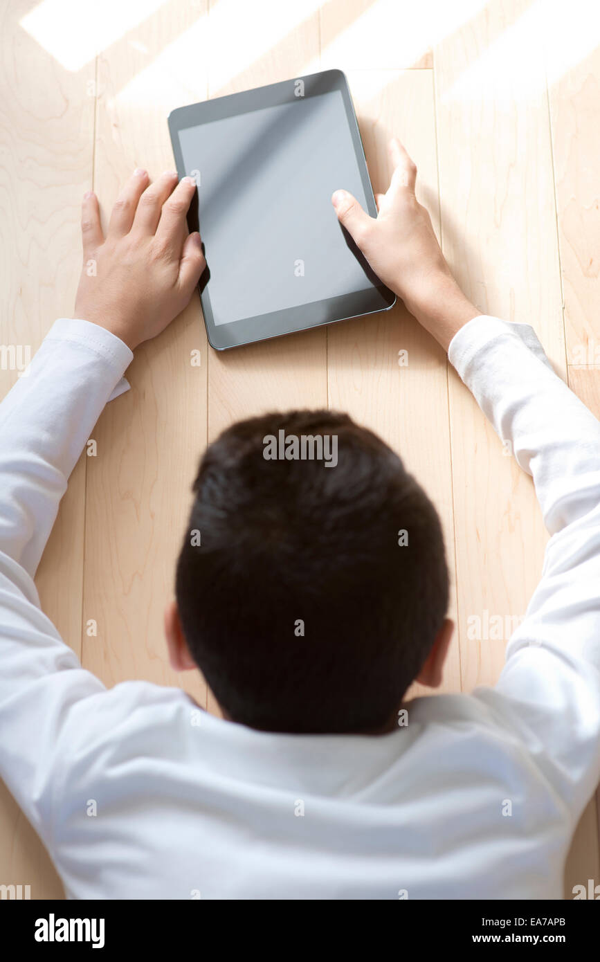 Young boy laying down with ipad tablet computer Stock Photo - Alamy