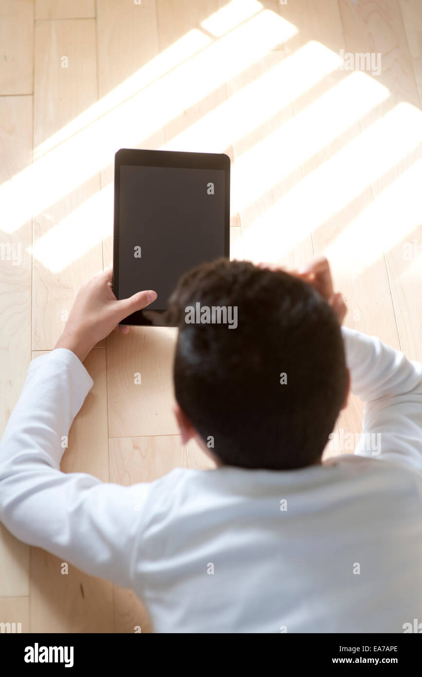 Young boy laying down with ipad tablet computer Stock Photo - Alamy