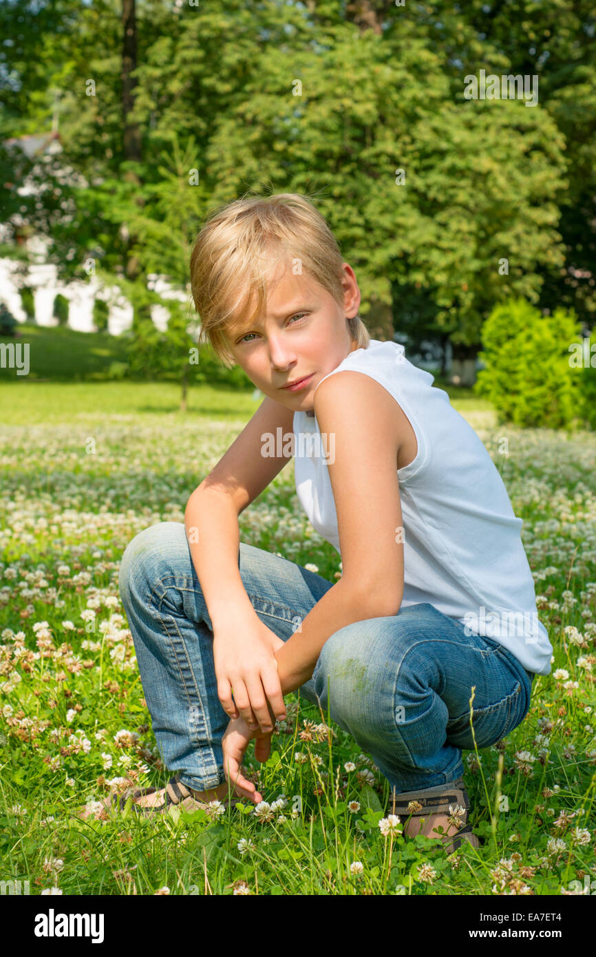 Boy sitting on grass Stock Photo - Alamy