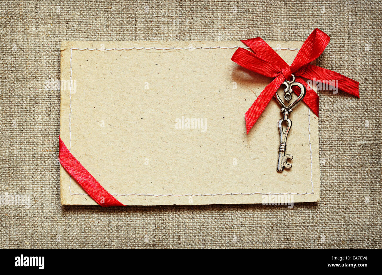 Greeting card with red ribbon and a key on canvas background Stock ...