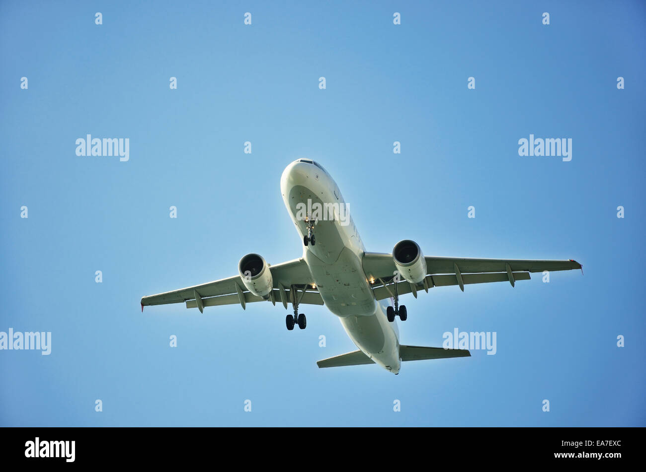 Airplane flying in blue sky Stock Photo - Alamy