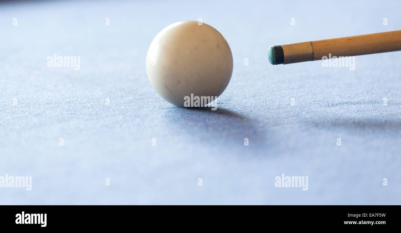 Pool cue and the white ball in shallow focus on a pool table Stock ...