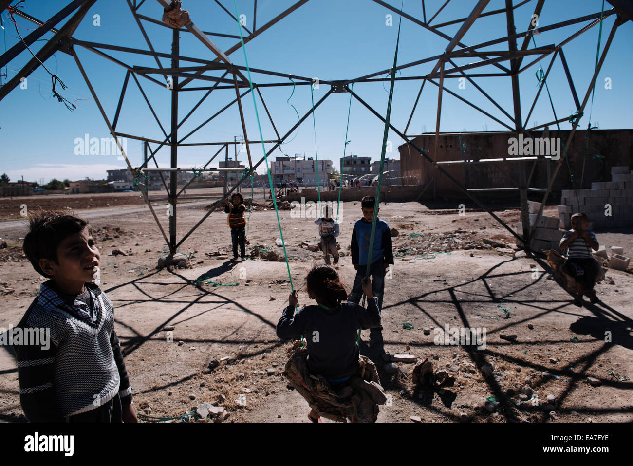 Kurdish refugee children swinging from an electricity column outside a ...