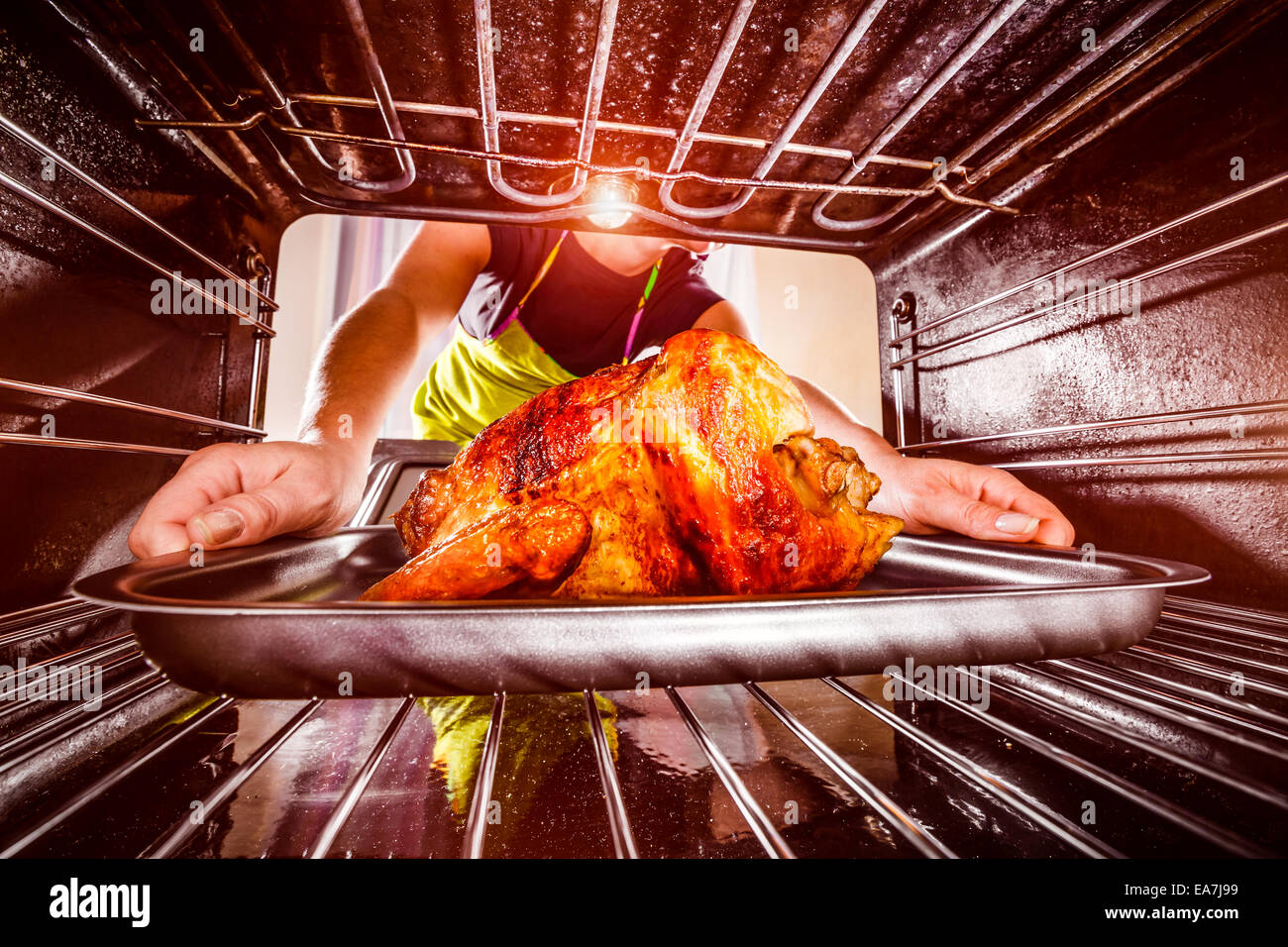 Housewife prepares roast chicken in the oven, view from the inside of ...
