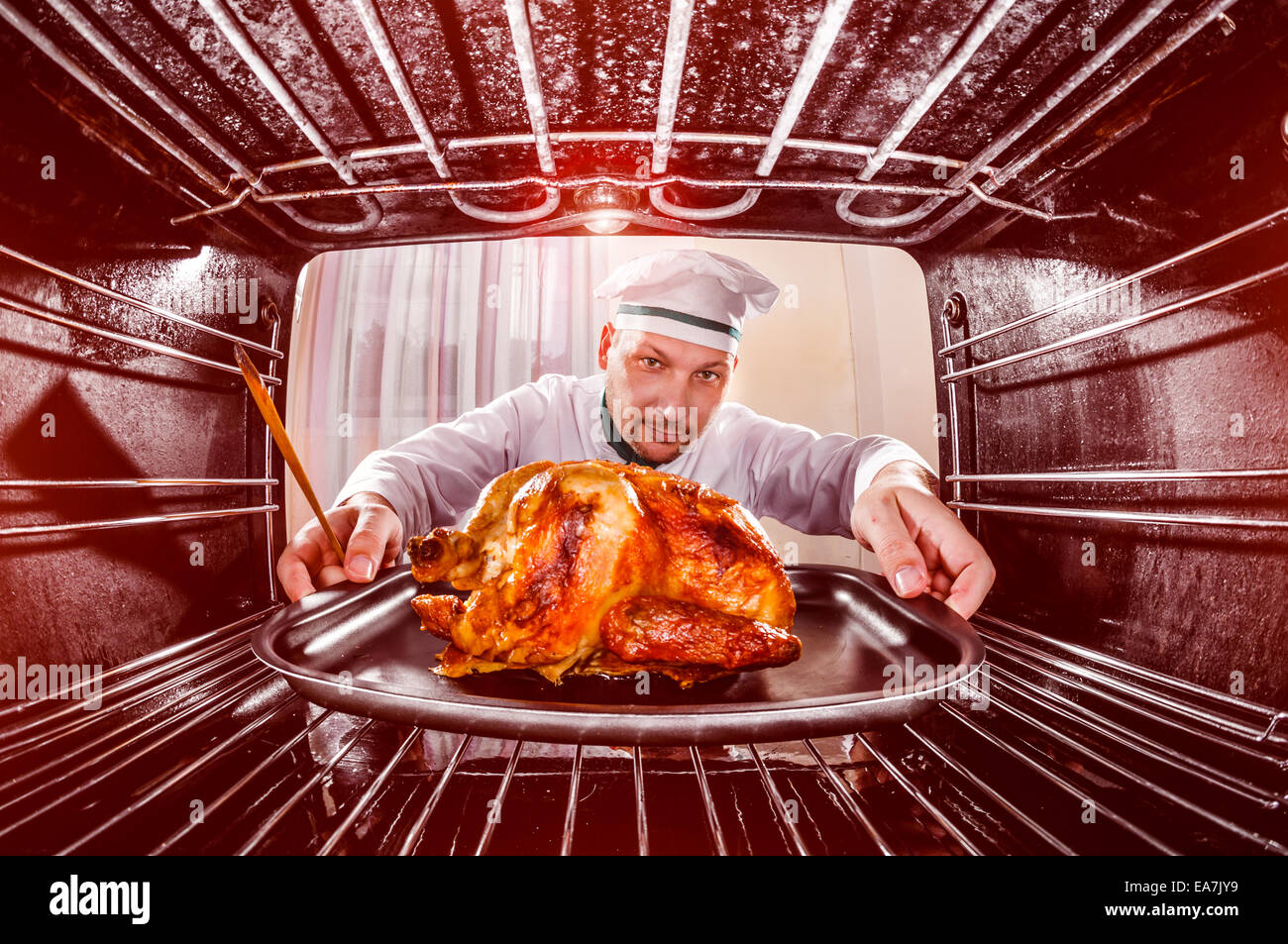 Chef prepares roast chicken in the oven, view from the inside of the ...