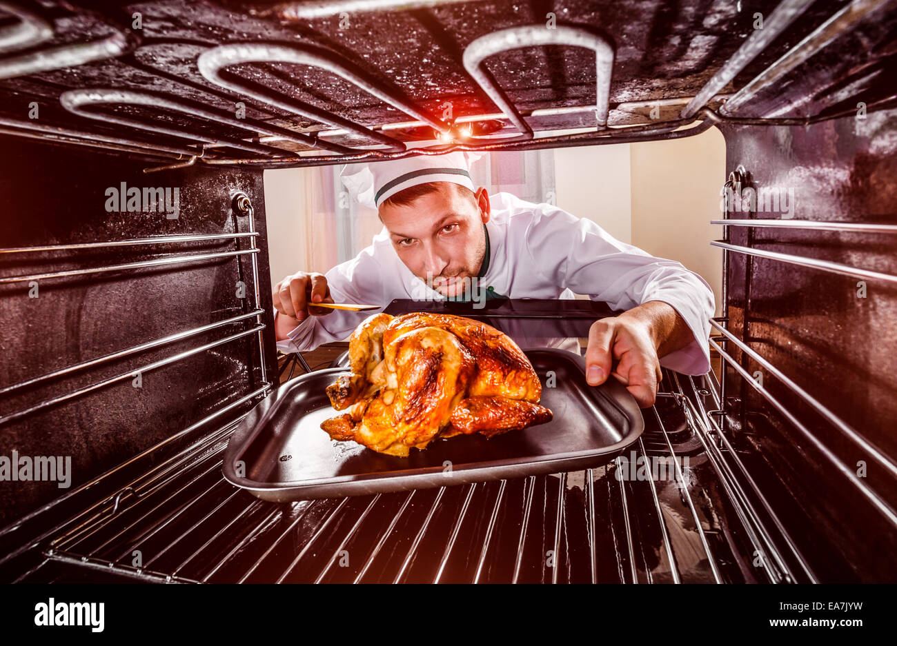 Chef prepares roast chicken in the oven, view from the inside of the ...