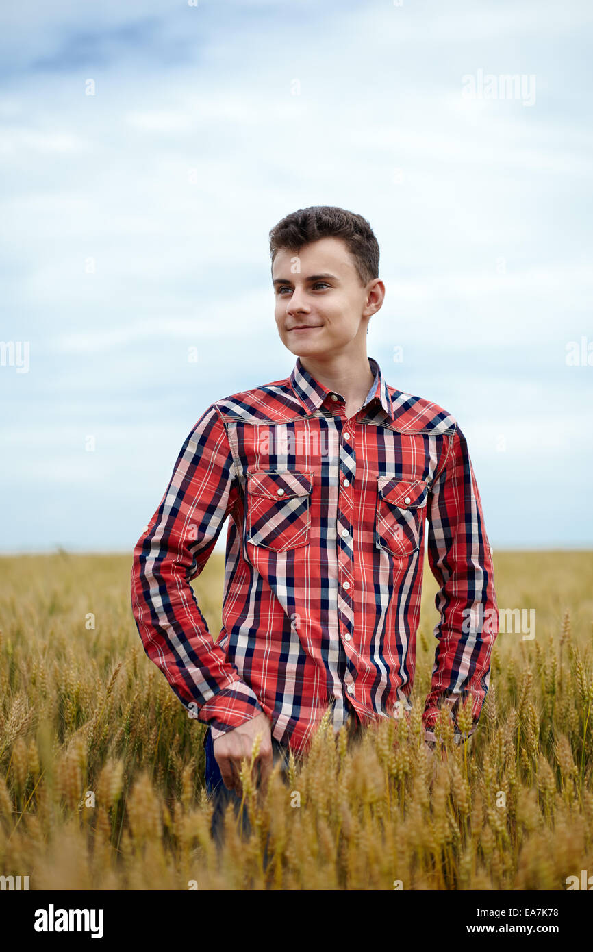 Closeup of a caucasian teenager boy standing in a wheat field, with ...