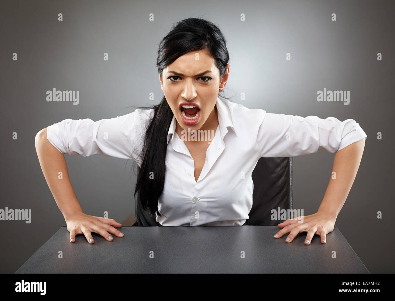 Angry business woman shouting with her hands on the desk Stock Photo ...