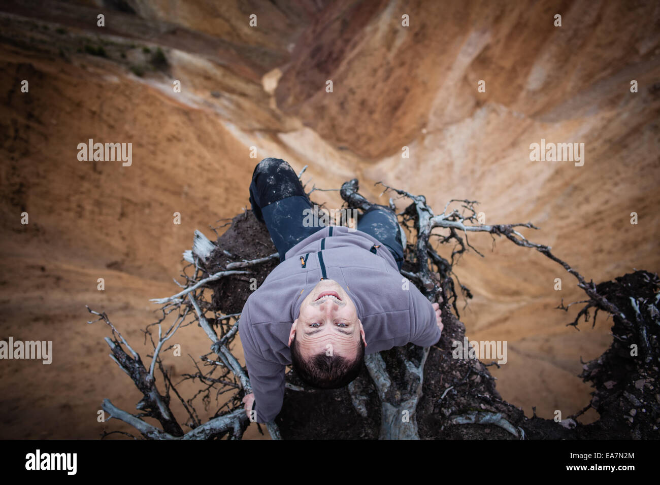 Man sitting on the edge of a high cliff, adrenaline, courage and risk ...