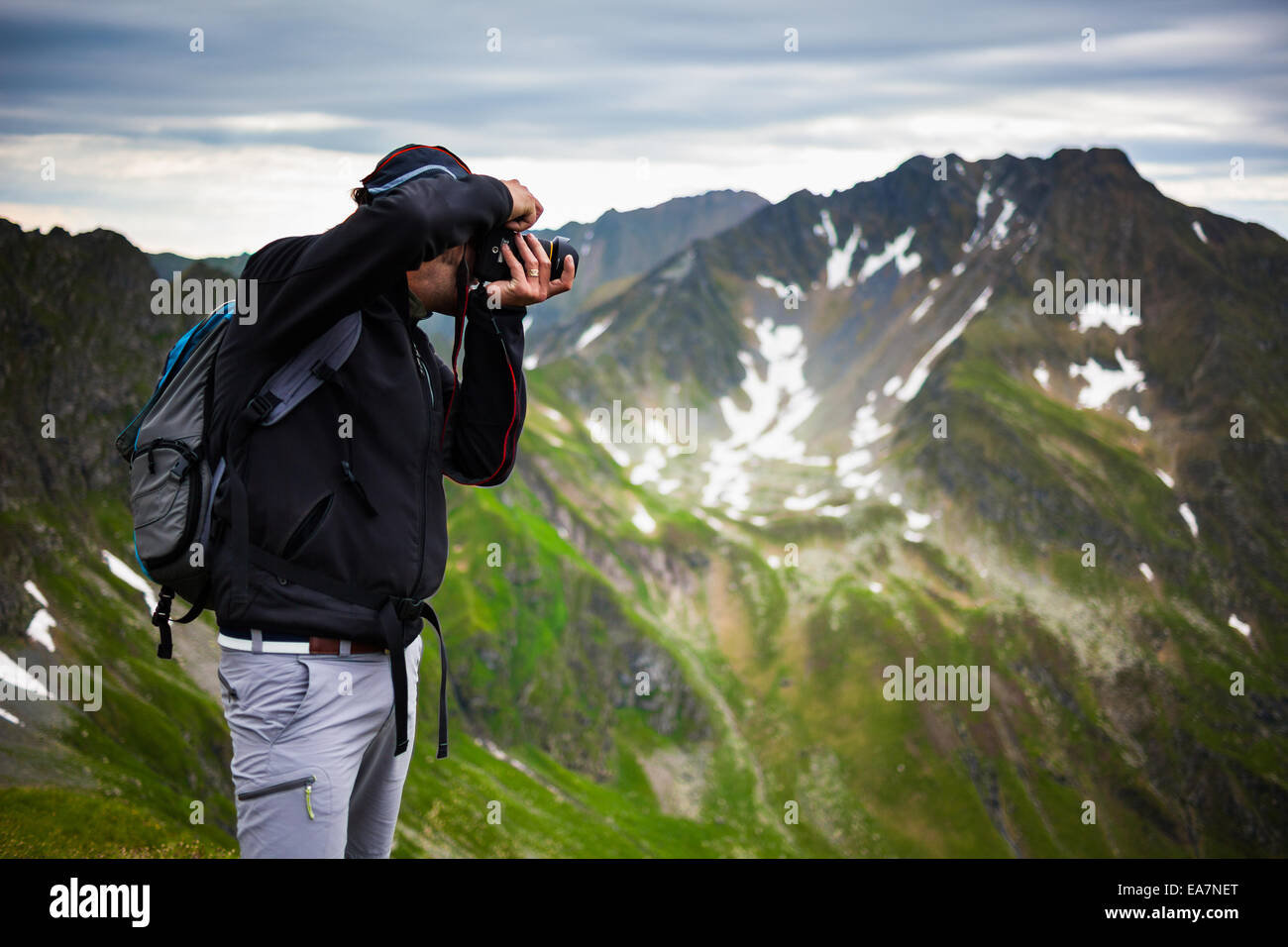 Hiking tourist taking photos of the alpine landscape Stock Photo - Alamy