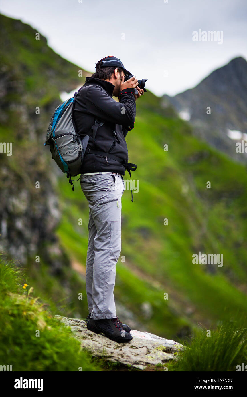 Hiking tourist taking photos of the alpine landscape Stock Photo - Alamy