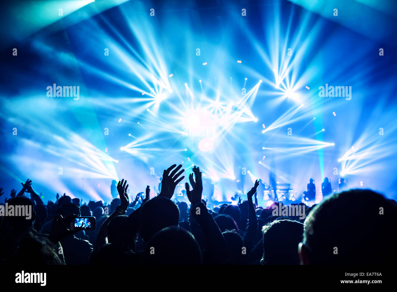 Large group of happy people enjoying rock concert, clapping with raised ...