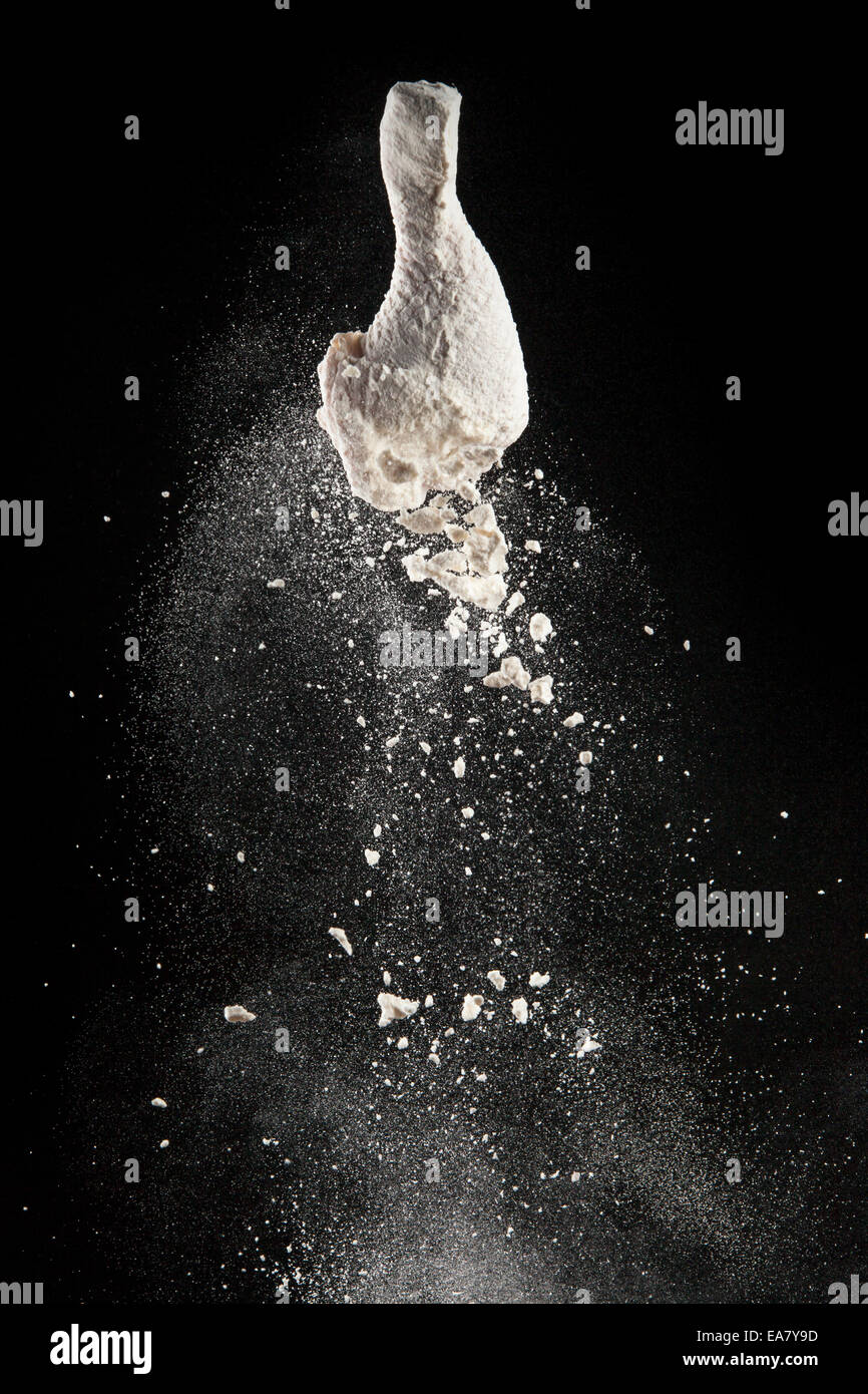 Chicken leg with flour in freeze motion, isolated on black background ...
