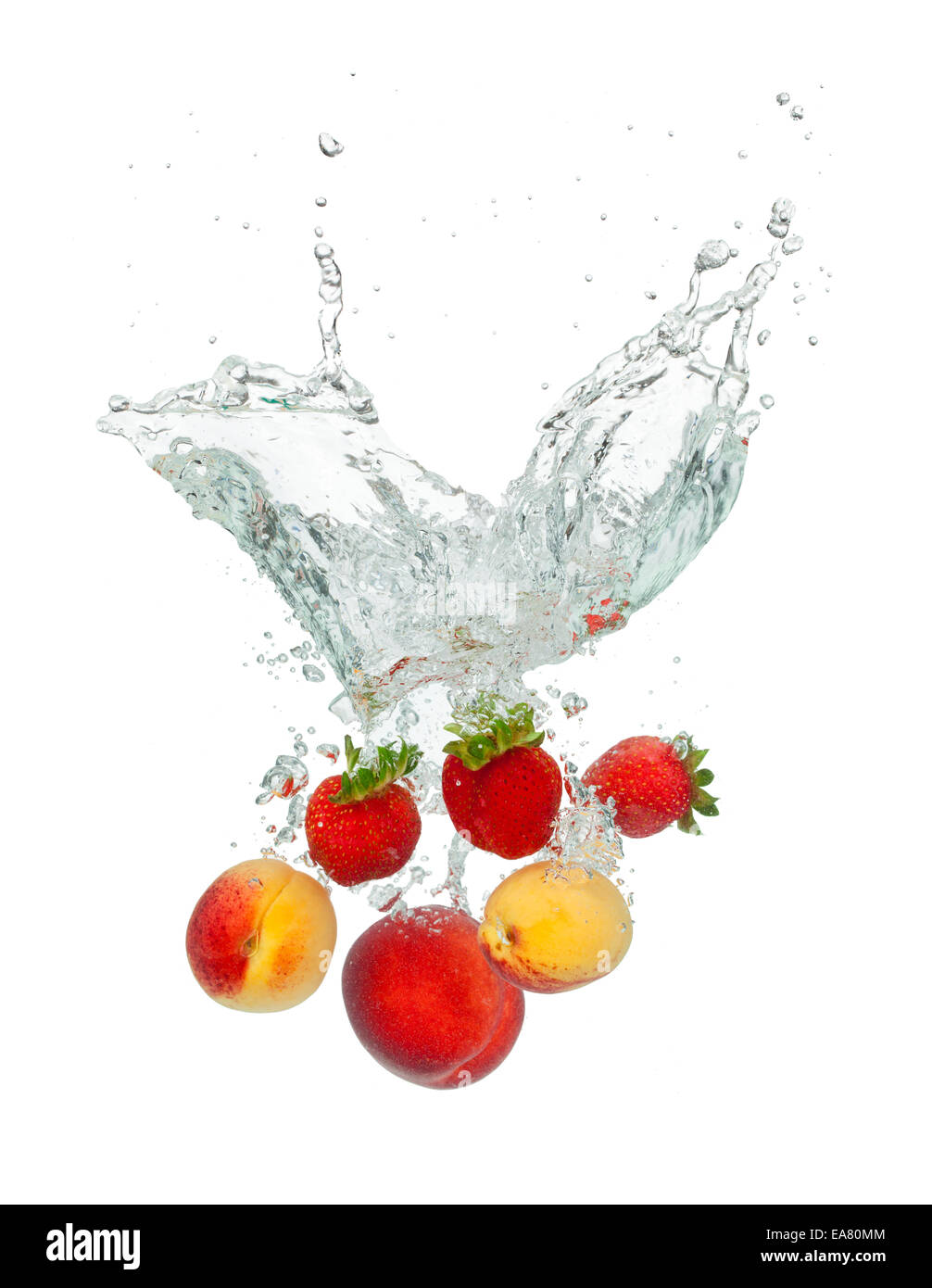 Isolated shot of fruit falling into water, isolated on white background ...