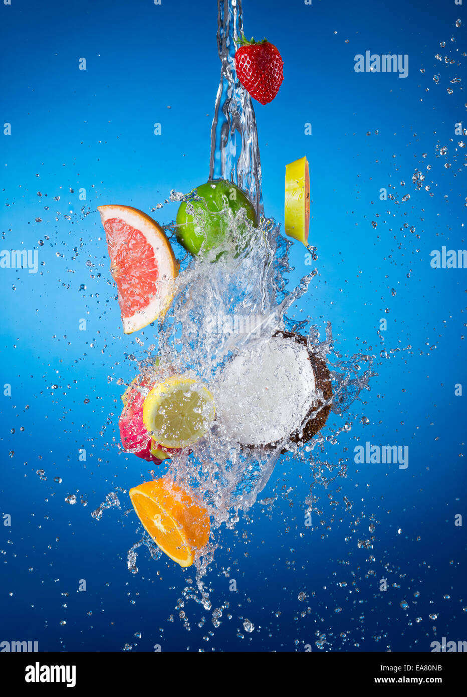 Studio shot of fresh exotic fruit with water splash, on blue background ...