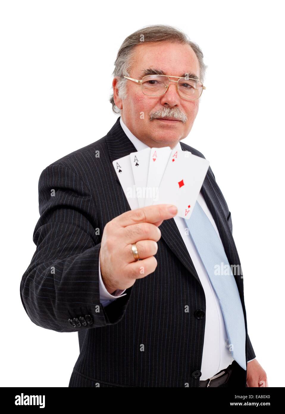 Senior man holding playing cards, showing all trumps, the four aces ...