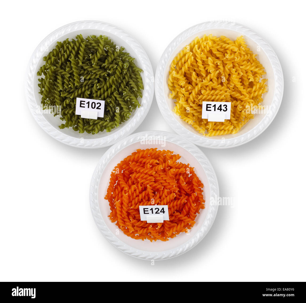 Top view of artificially colored twisted pasta in plates, with colorant ...