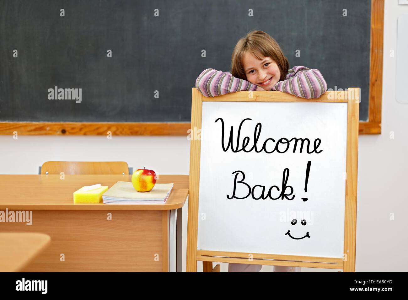 School girl in classroom, behind a board with Welcome Back script Stock ...