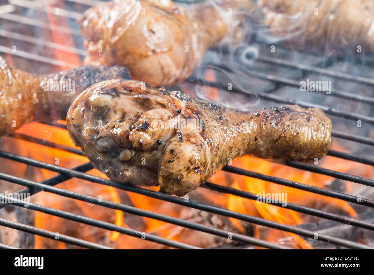 Chicken legs on barbecue grill with fire Stock Photo - Alamy