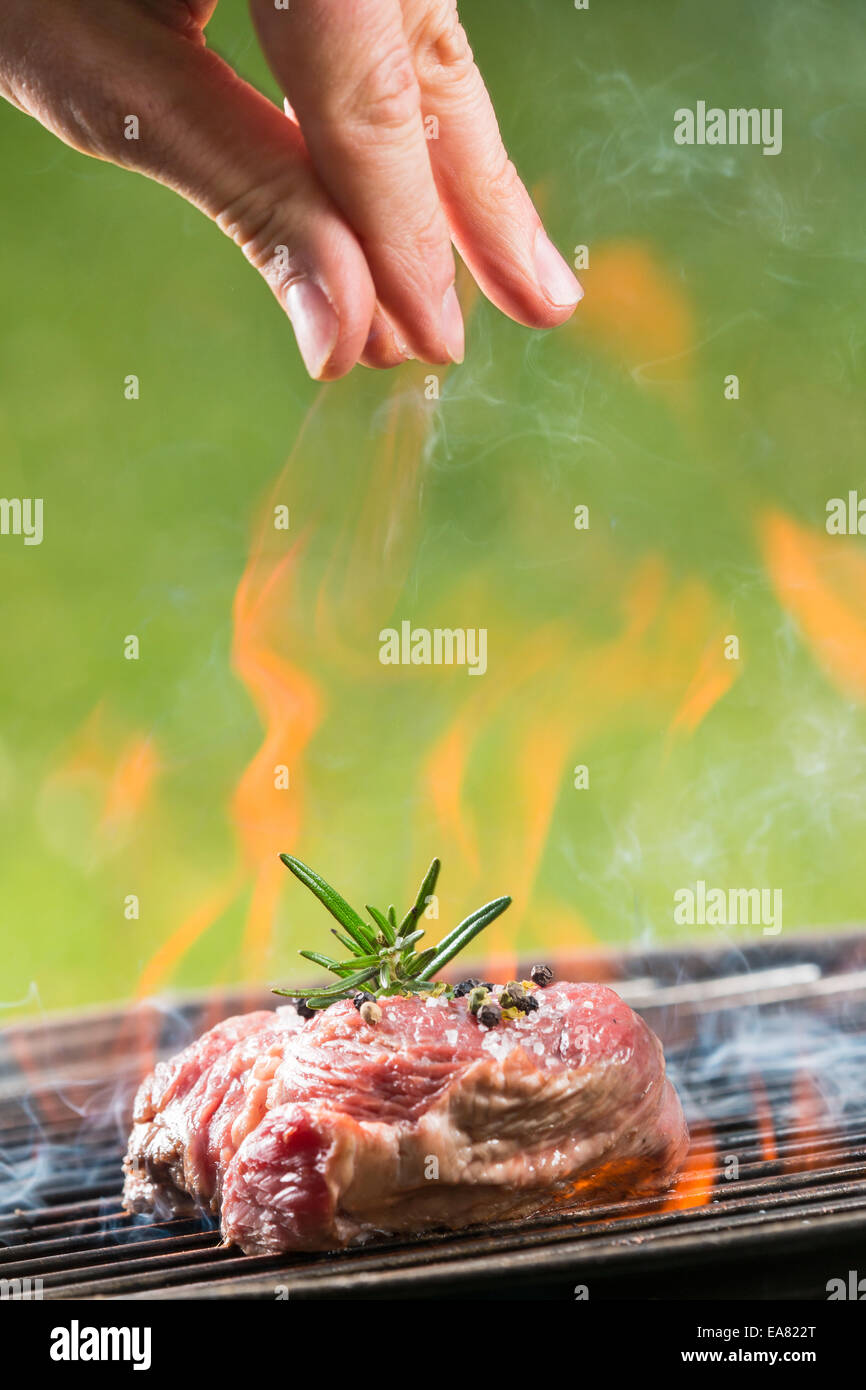 Delicious grilled beef steaks burning on fire Stock Photo - Alamy