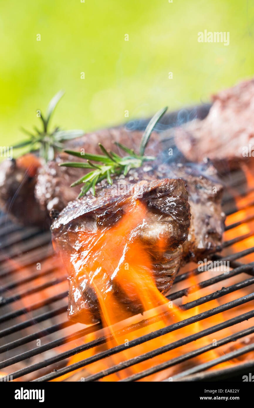 Delicious grilled beef steaks burning on fire Stock Photo - Alamy